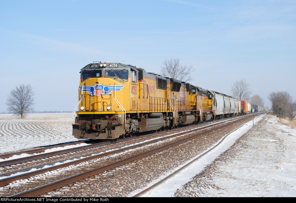 Charging south into the countryside is Union Pacific 4058 with a mix of freight